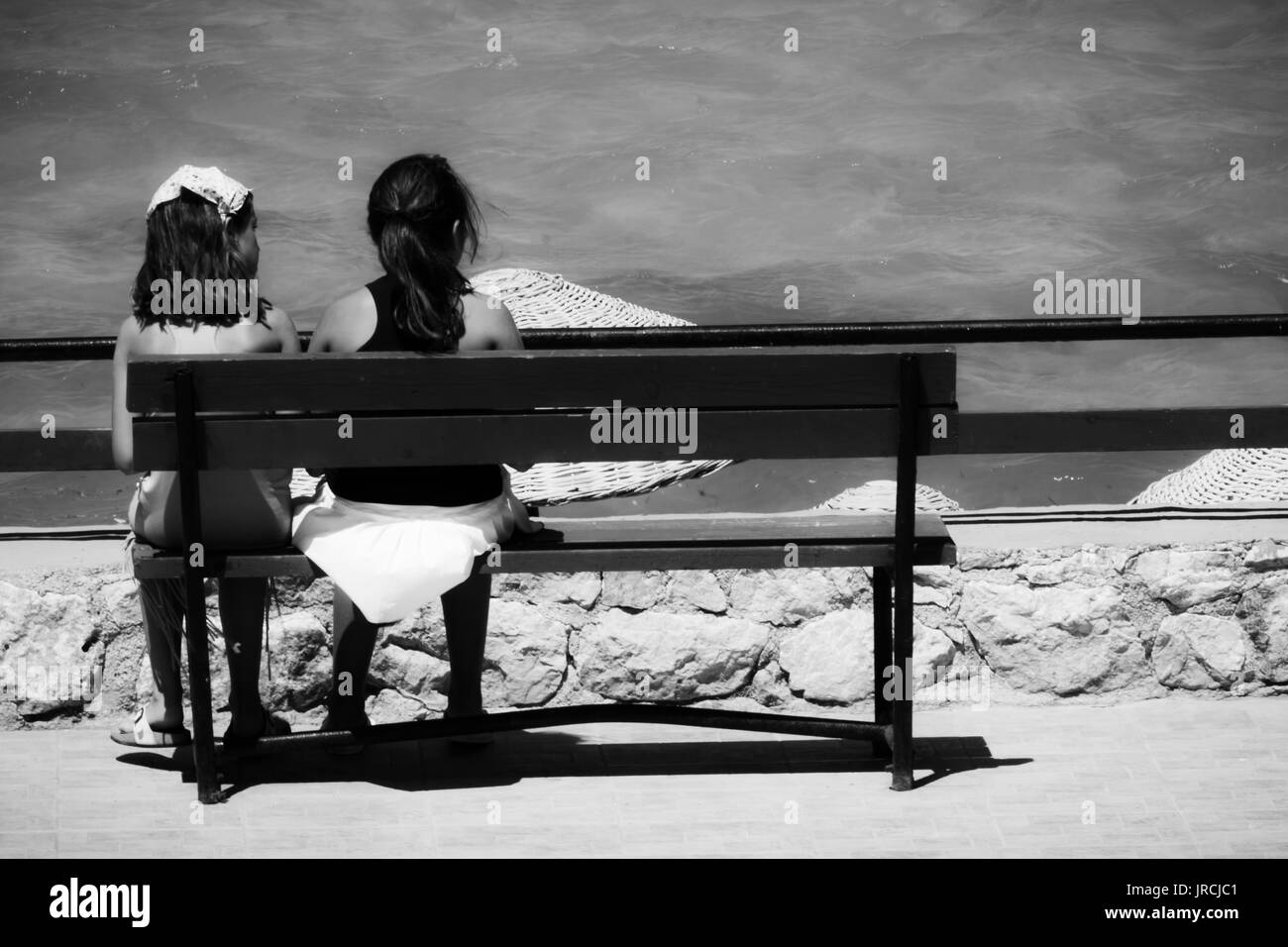 Two girls talking on bench hi-res stock photography and images - Alamy