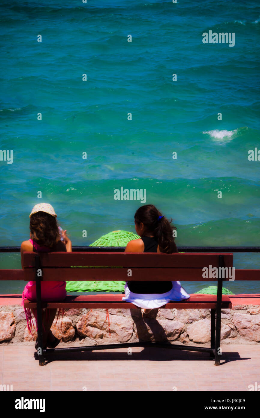 Two girls talking on bench hi-res stock photography and images - Alamy