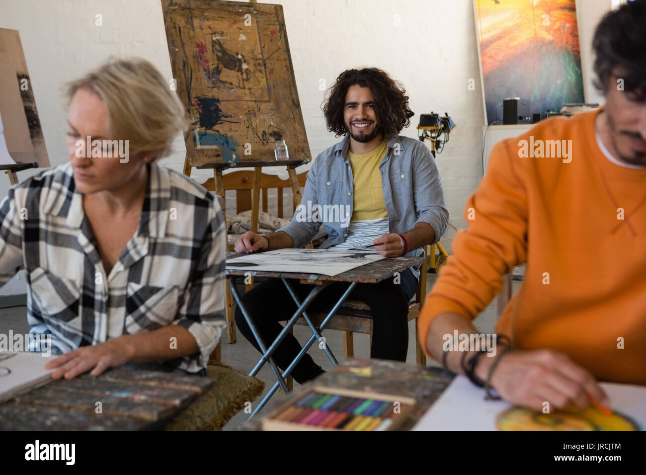 Portrait of man with friends practicing painting in art class Stock ...