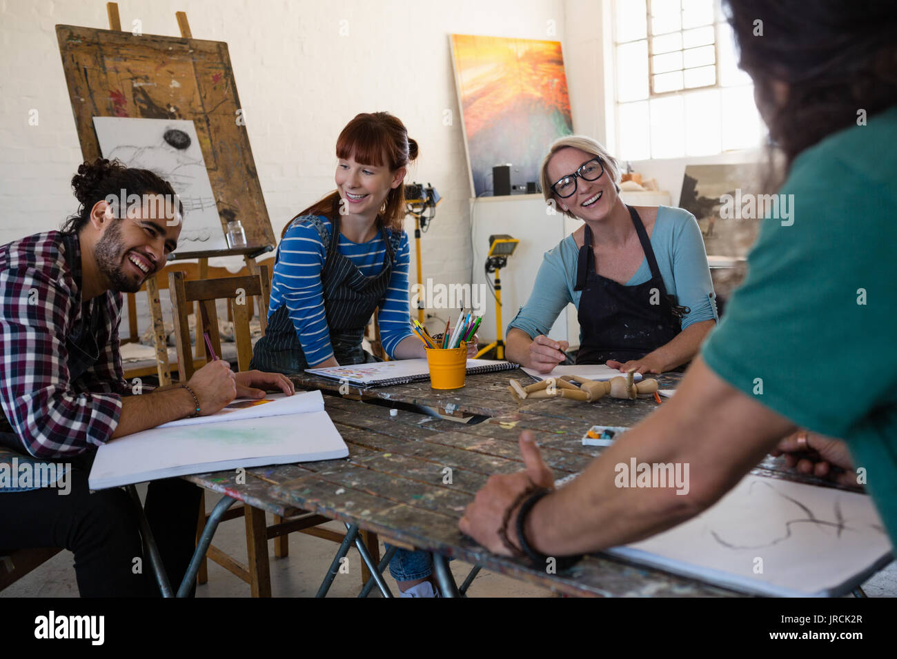 Happy adult students talking while practicing in art class Stock Photo ...