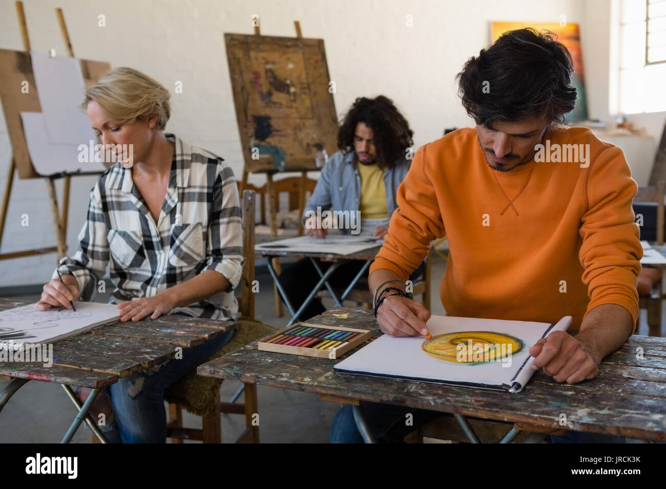 Adult students practicing painting on book at table in art class Stock ...
