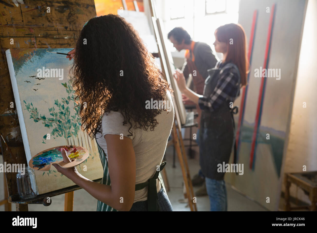 Adult friends painting on artists canvas in art class Stock Photo - Alamy