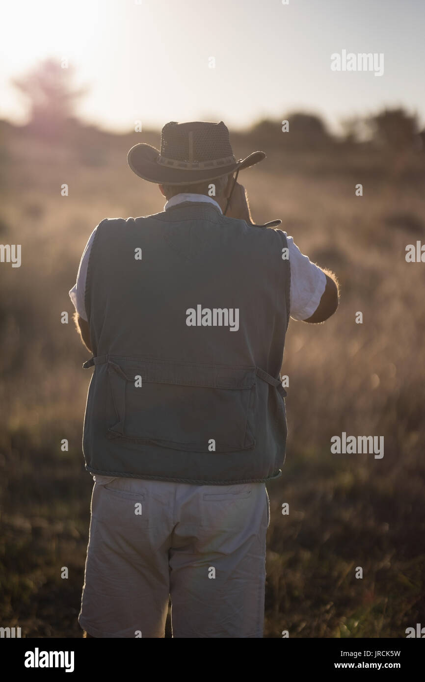 Rear view of man taking picture during safari vacation Stock Photo - Alamy