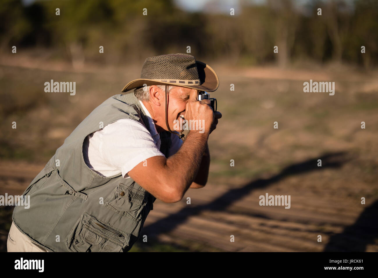 Man taking picture with camera during safari vacation Stock Photo - Alamy