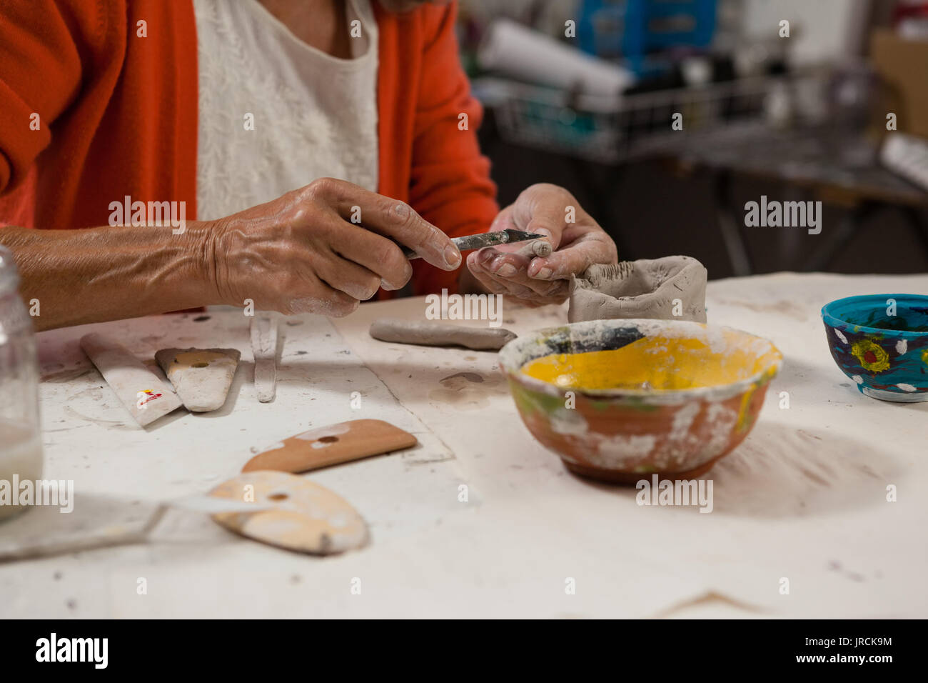 Mid-section of senior woman shaping a clay pot in class Stock Photo - Alamy