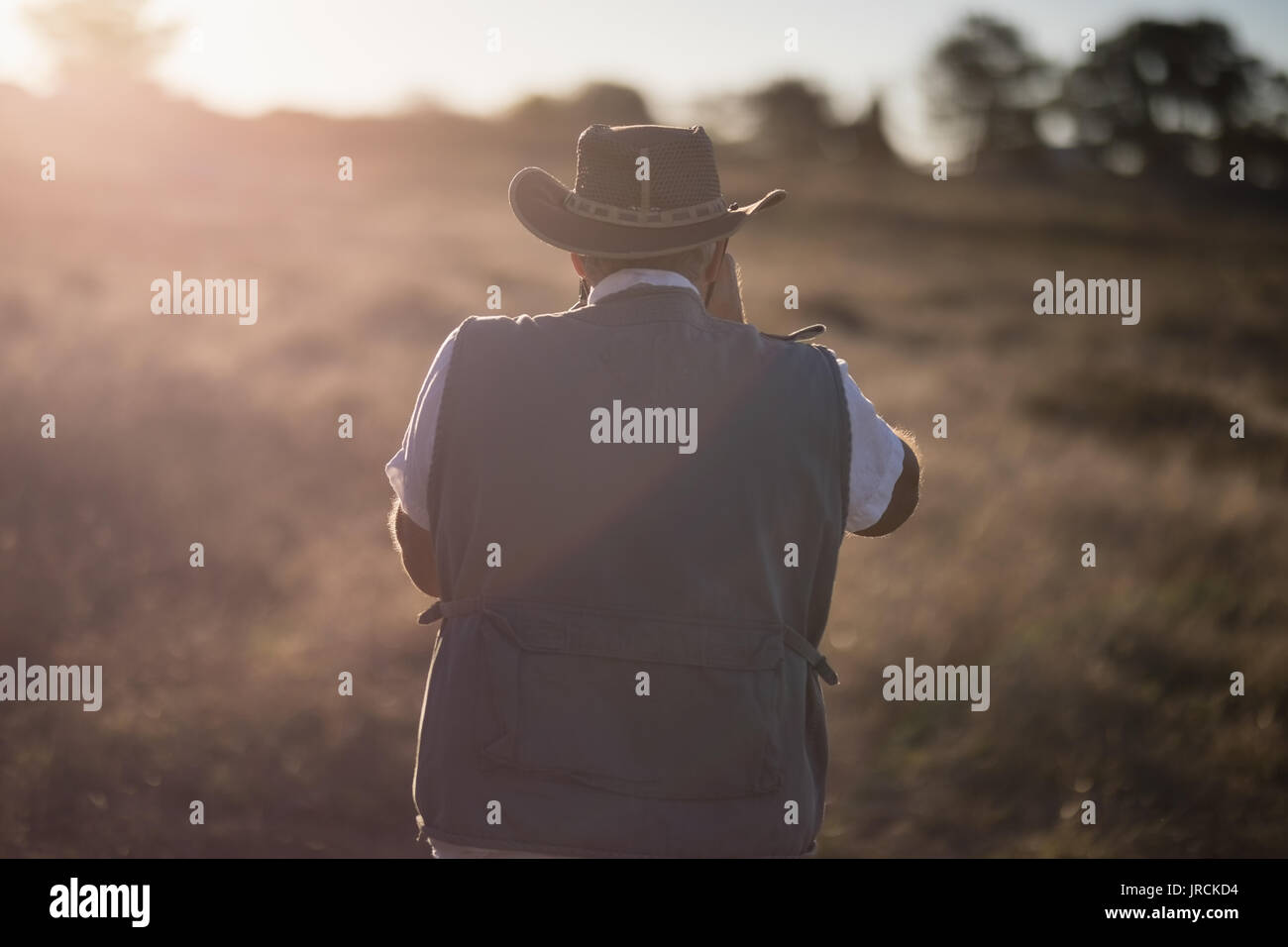 Rear view of man taking picture during safari vacation Stock Photo - Alamy