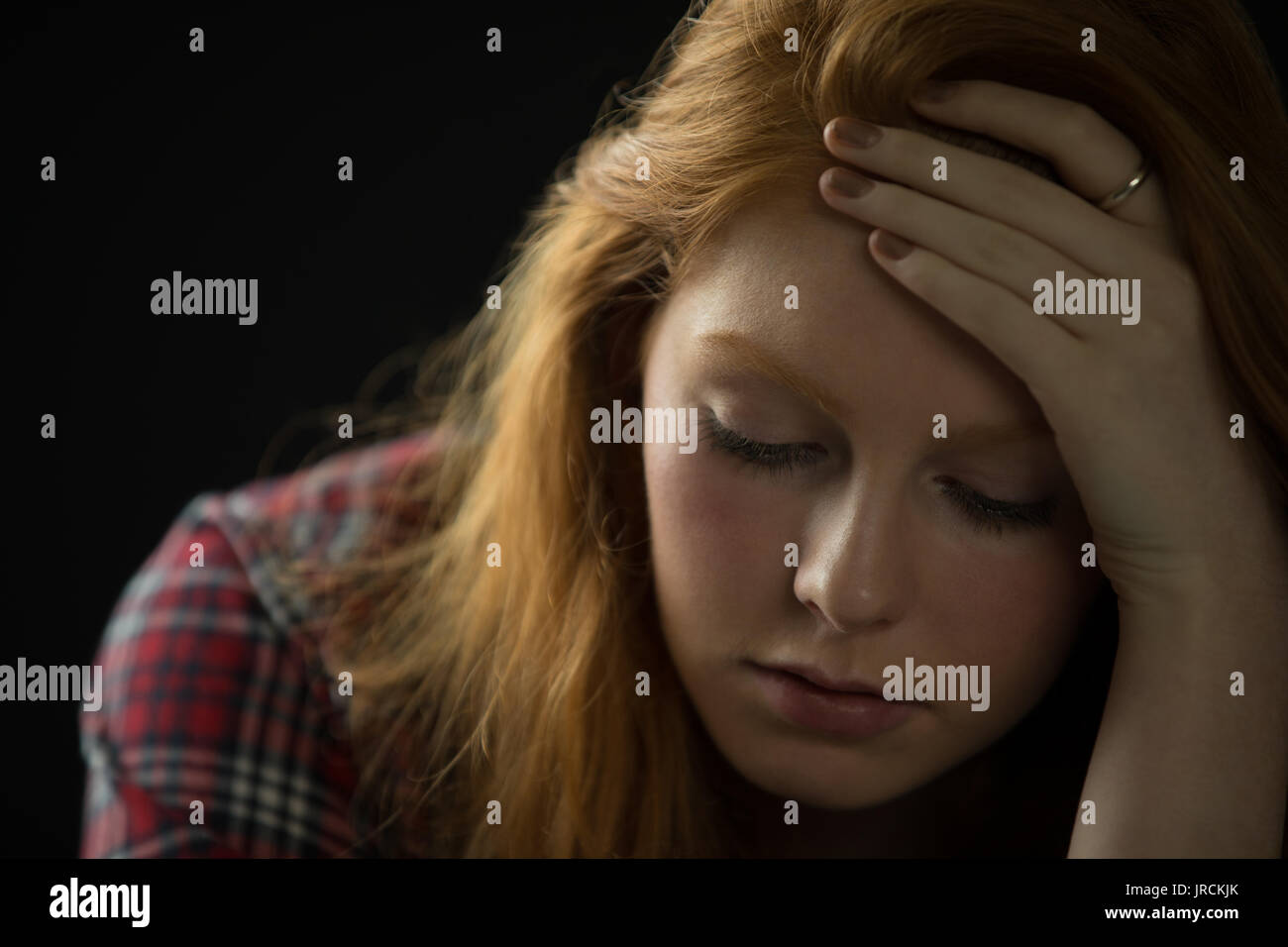 Young woman with head in hand hi-res stock photography and images - Alamy