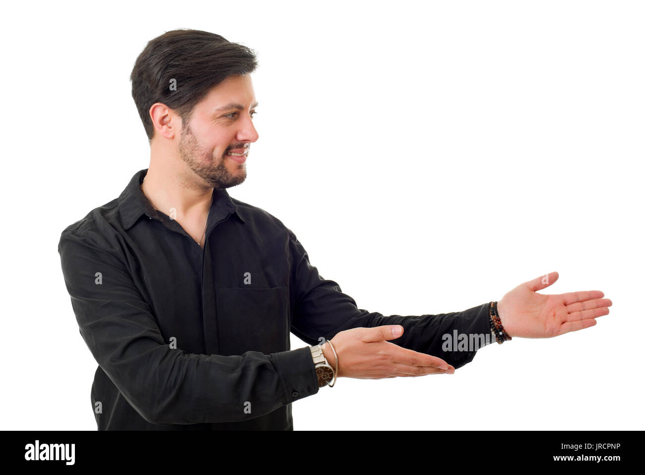 friendly young man pointing to his side and looking into the camera ...