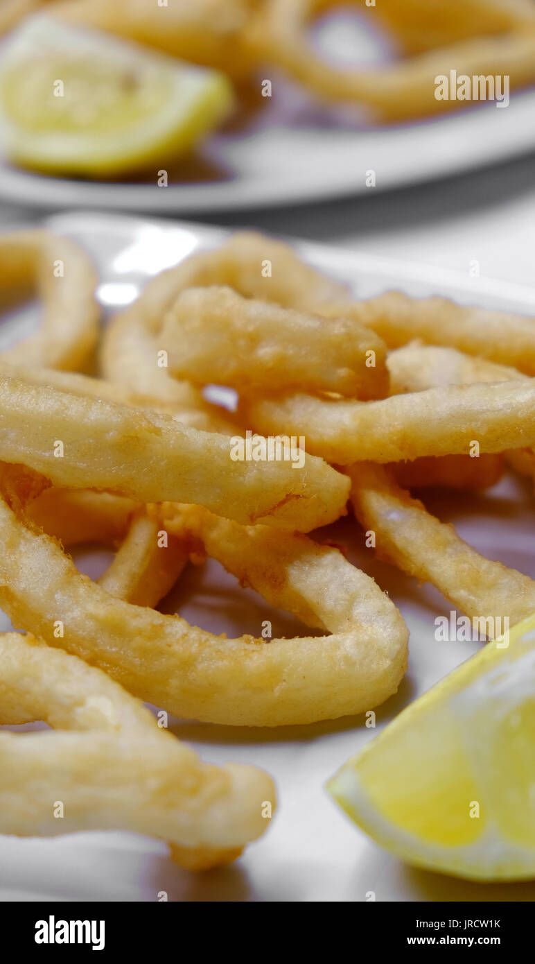 Fried calamari rings isolated on a white plate.Close up shot Stock ...