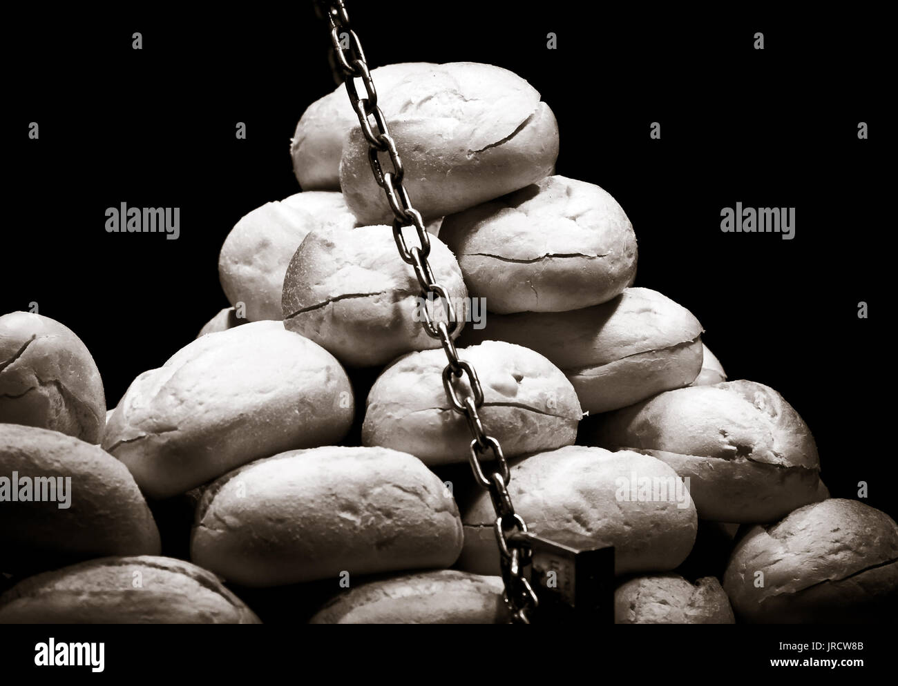 Fine art black and white photo showing a heap of bread with a chain and ...