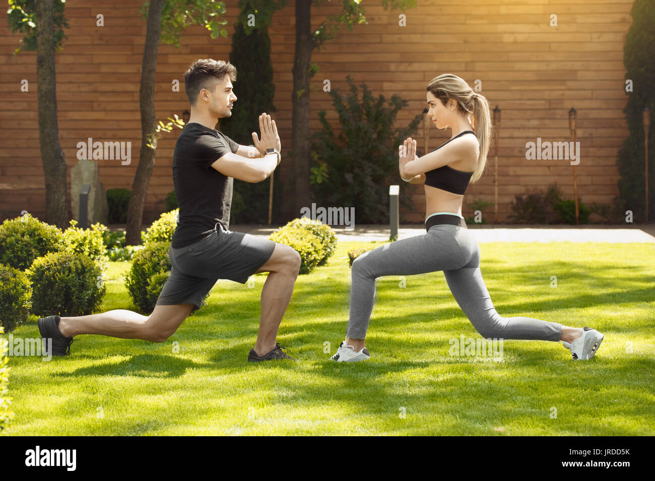Young man and woman exercise together yoga Stock Photo - Alamy