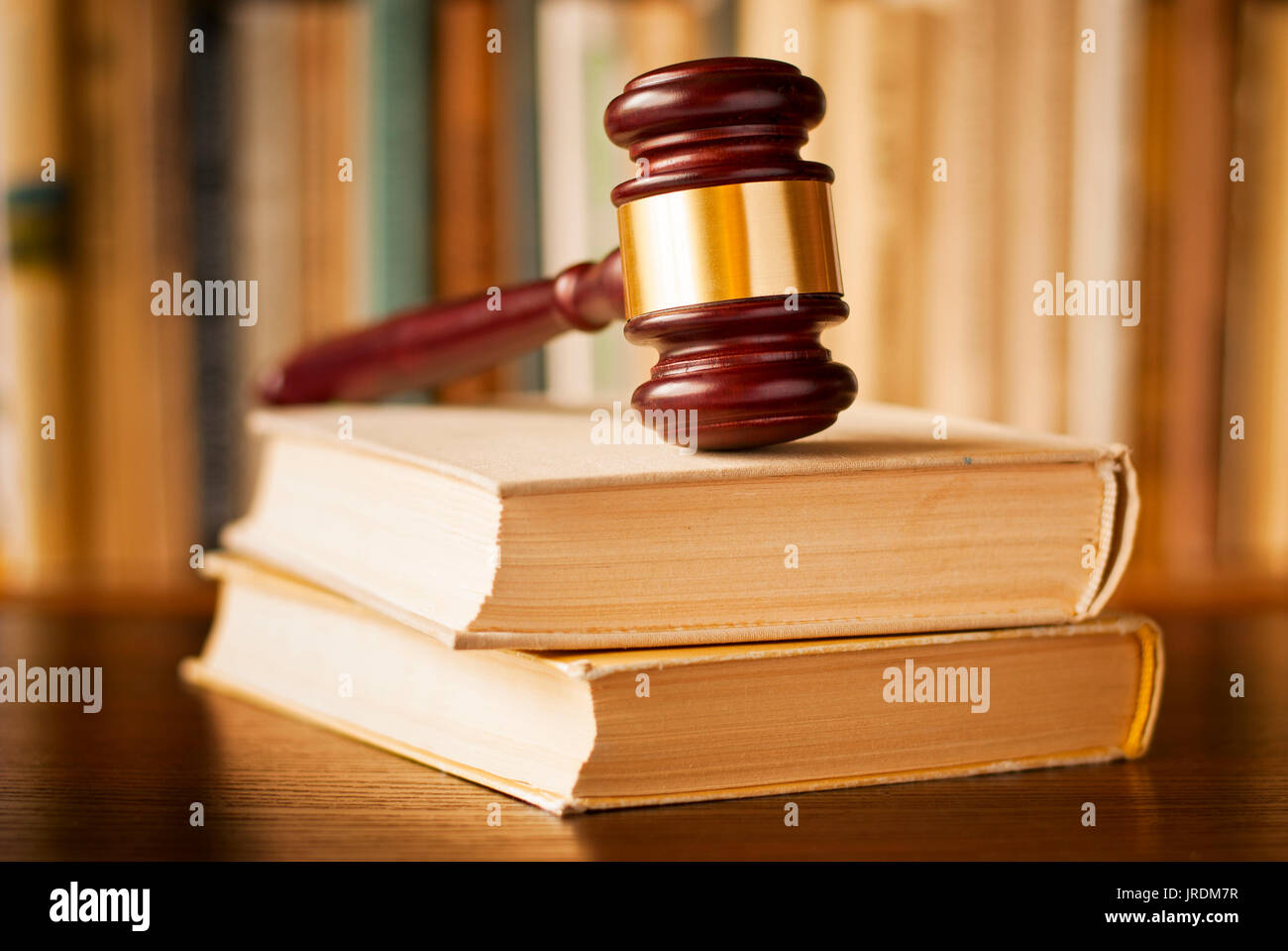 Law books with a wood and brass judges gavel resting on top on a wooden ...