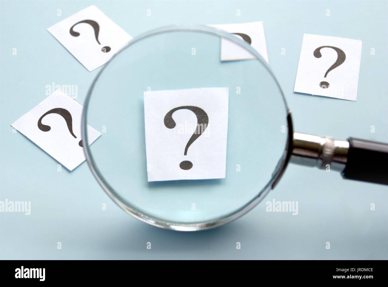 magnifying glass and a question mark on the paper Stock Photo - Alamy