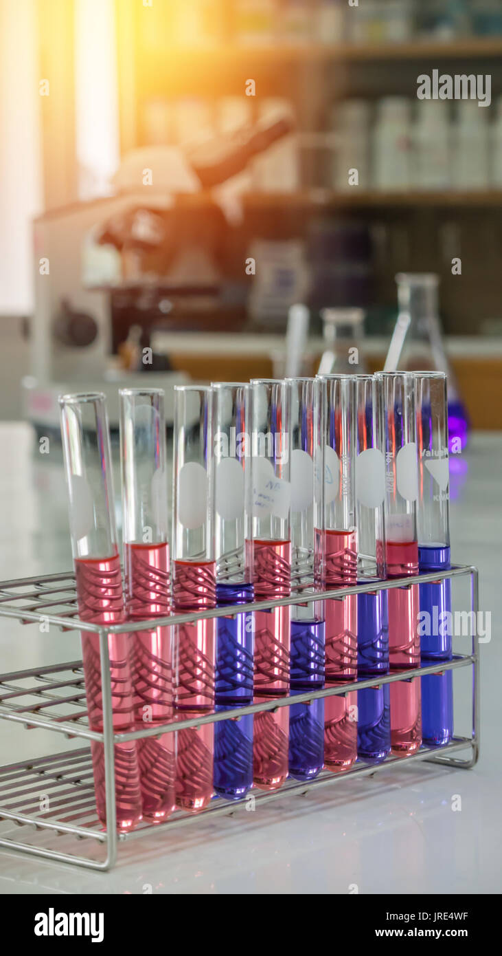 Different laboratory test tubes with colored liquid and with reflection ...