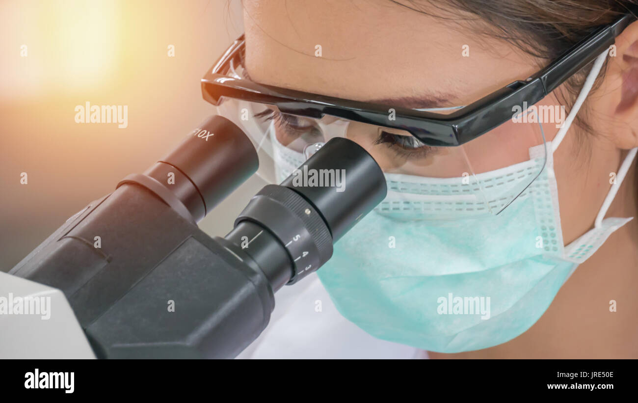 scientist looking through a microscope in a laboratory Stock Photo - Alamy