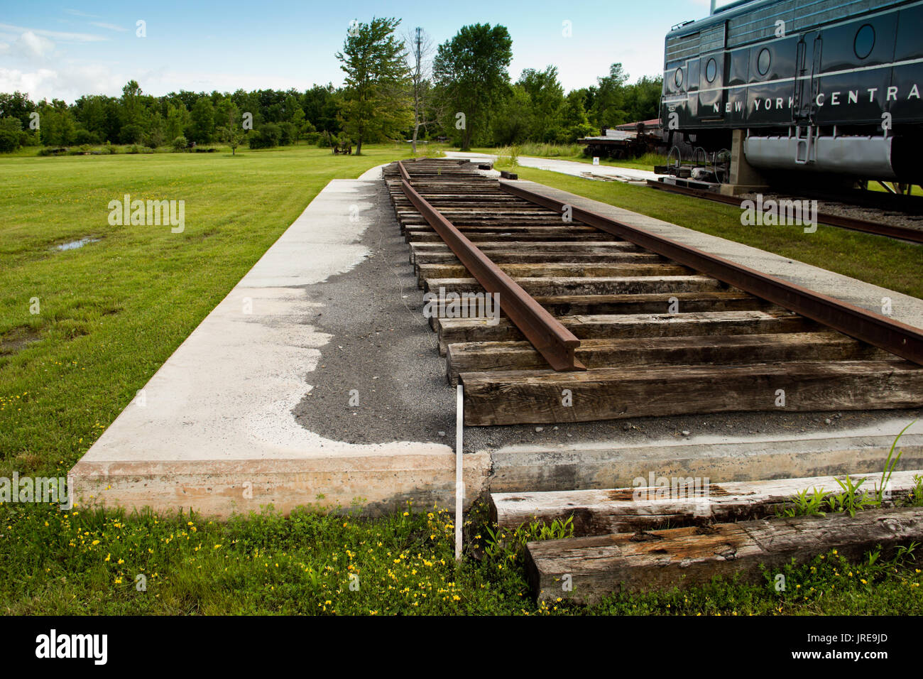 Train tracks alongside a locomotive rest on a concrete pad in the ...