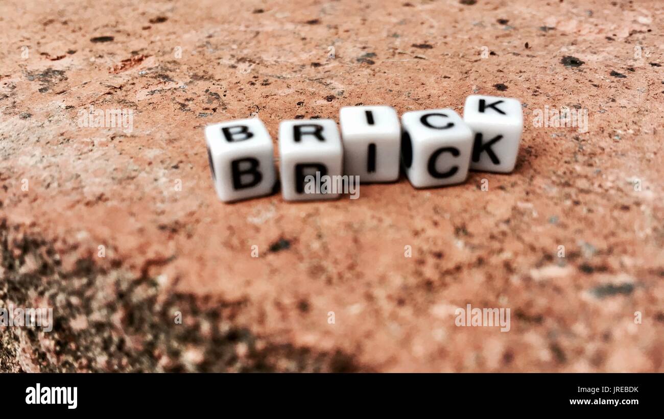 Brick inscription on brown brick. White letters building concept Stock ...
