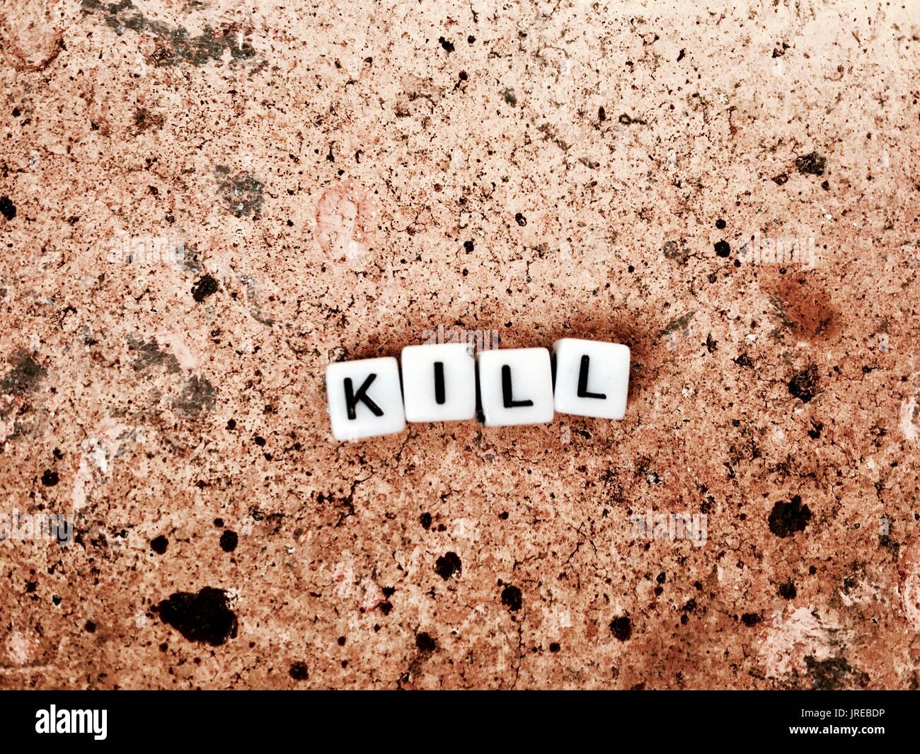 White inscription. Small white square letters. Kill on the brown brick ...