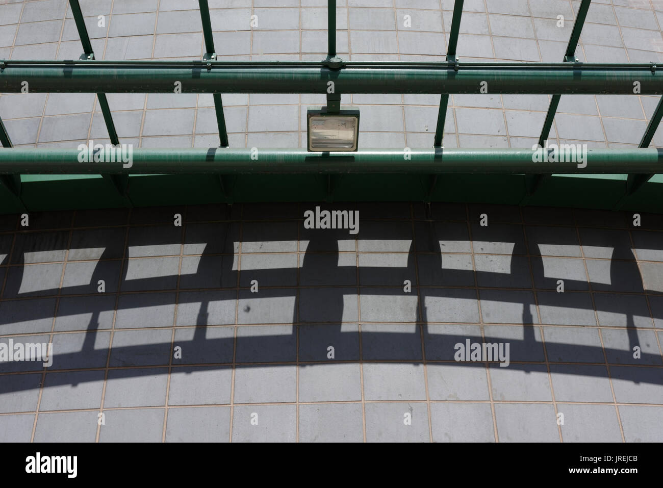 Green steel tubular frame and glass canopy attached to grey tiled ...