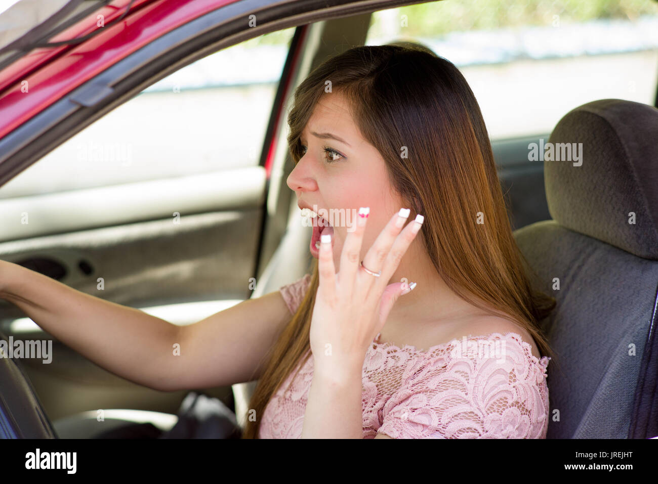Pretty young woman with surprised face driving her new red car Stock ...