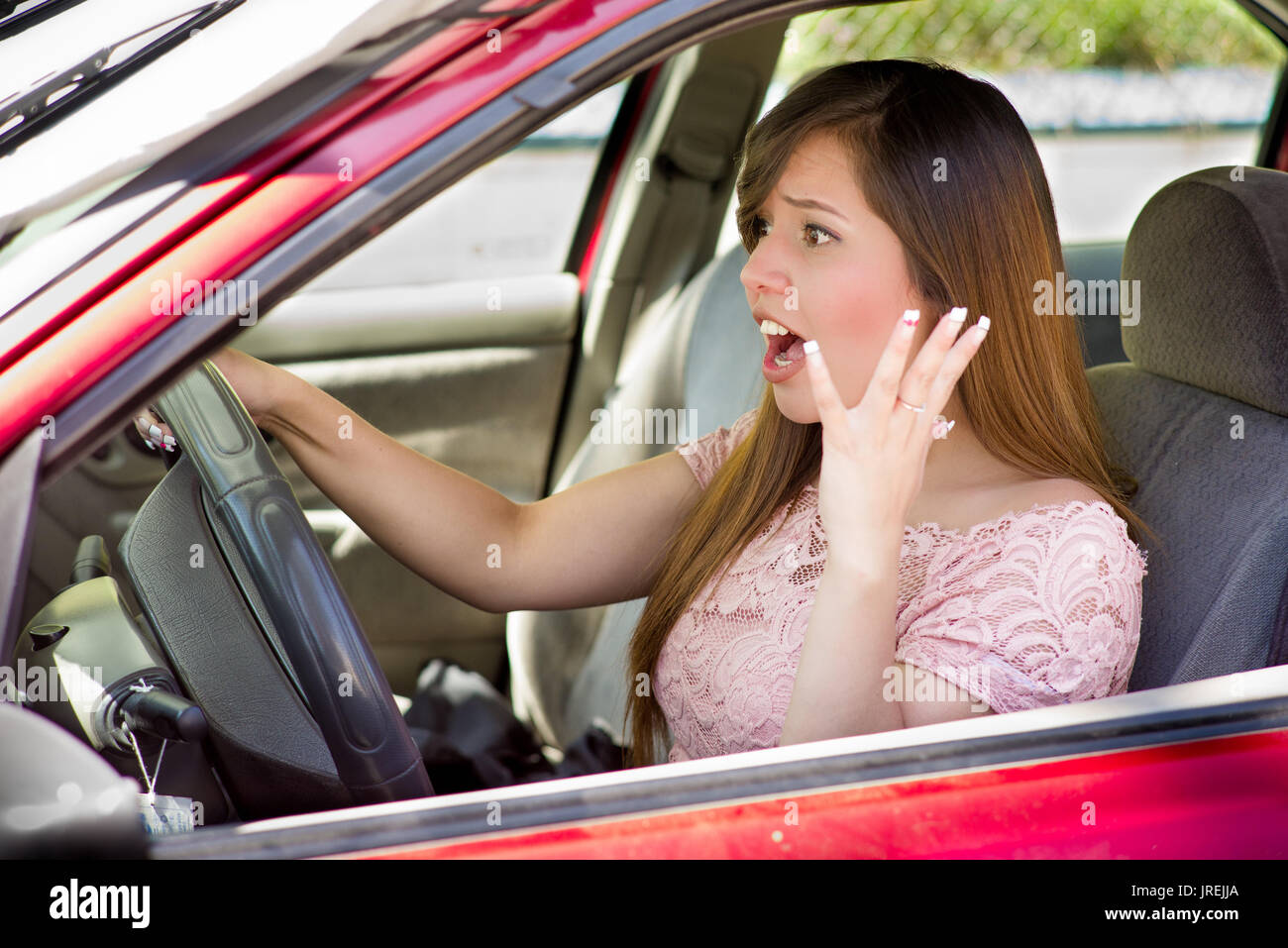 Pretty young woman with surprised face driving her new red car Stock ...