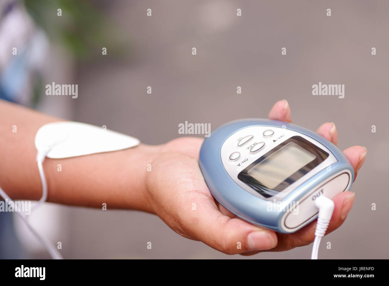 Close-up of a woman holding an electrode machine in her hand and with ...