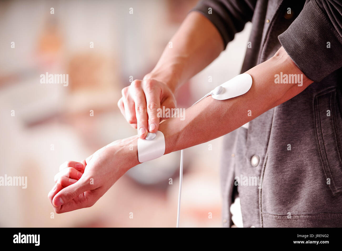 Close-up with electrostimulator electrodes in the arm of a fitness ...