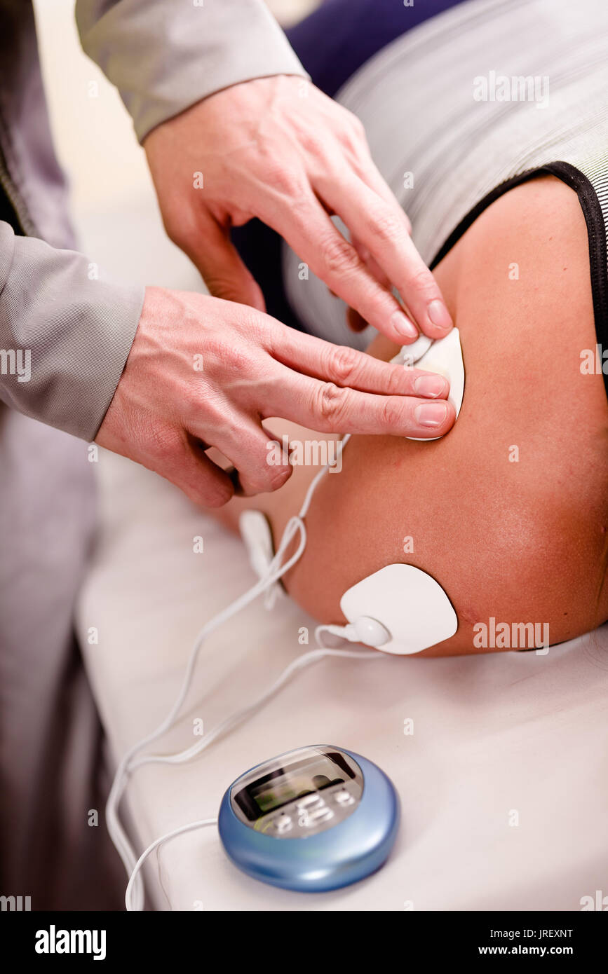 Close-up of a personal trainer hand putting an electrostimulator ...