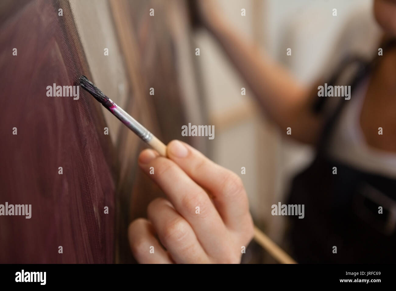 Mid-section of woman painting on canvas in drawing class Stock Photo ...