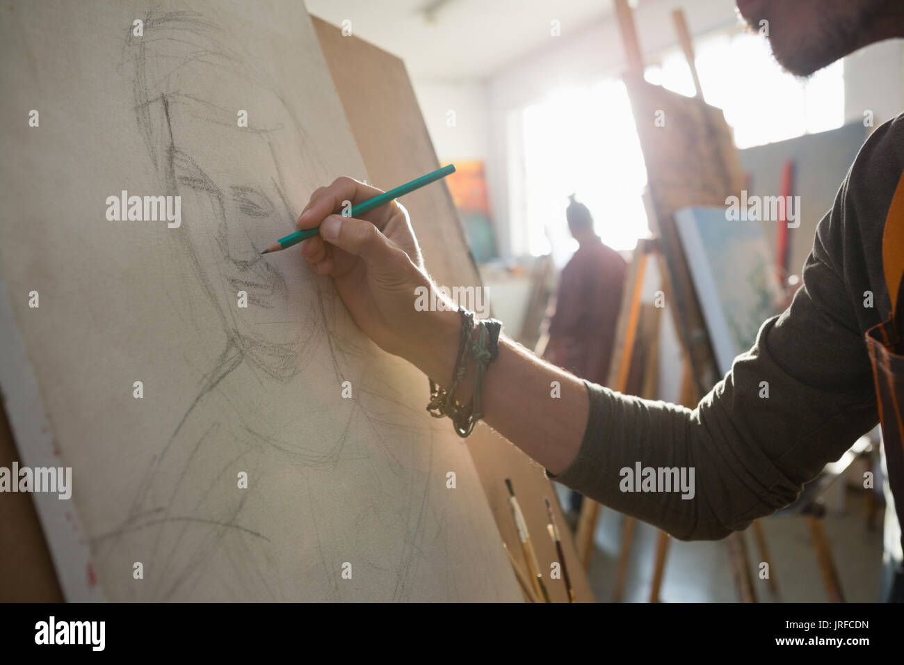 Cropped image of man sketching on canvas in art class Stock Photo - Alamy