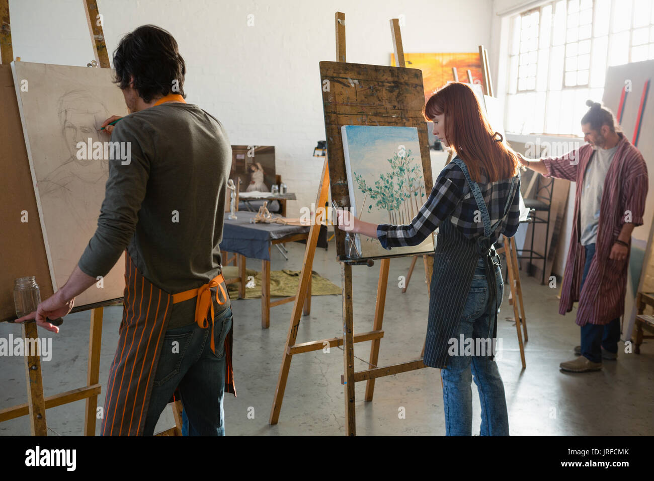 Artists painting on canvas while standing in art class Stock Photo - Alamy