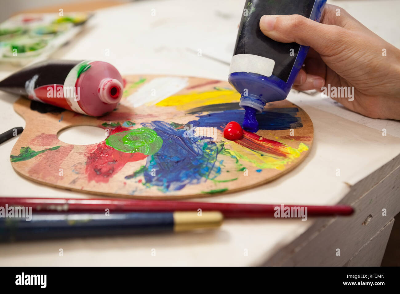 Hand of woman putting blue color in palette at drawing class Stock ...