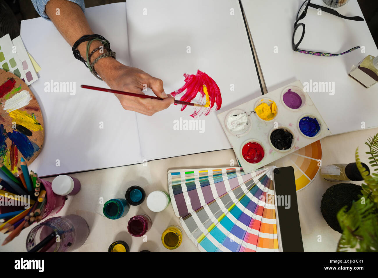 Woman painting in drawing book at drawing class Stock Photo - Alamy