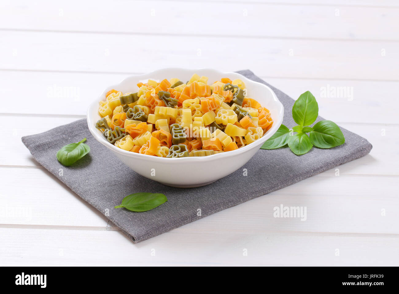 bowl of raw colored pasta on grey place mat Stock Photo - Alamy