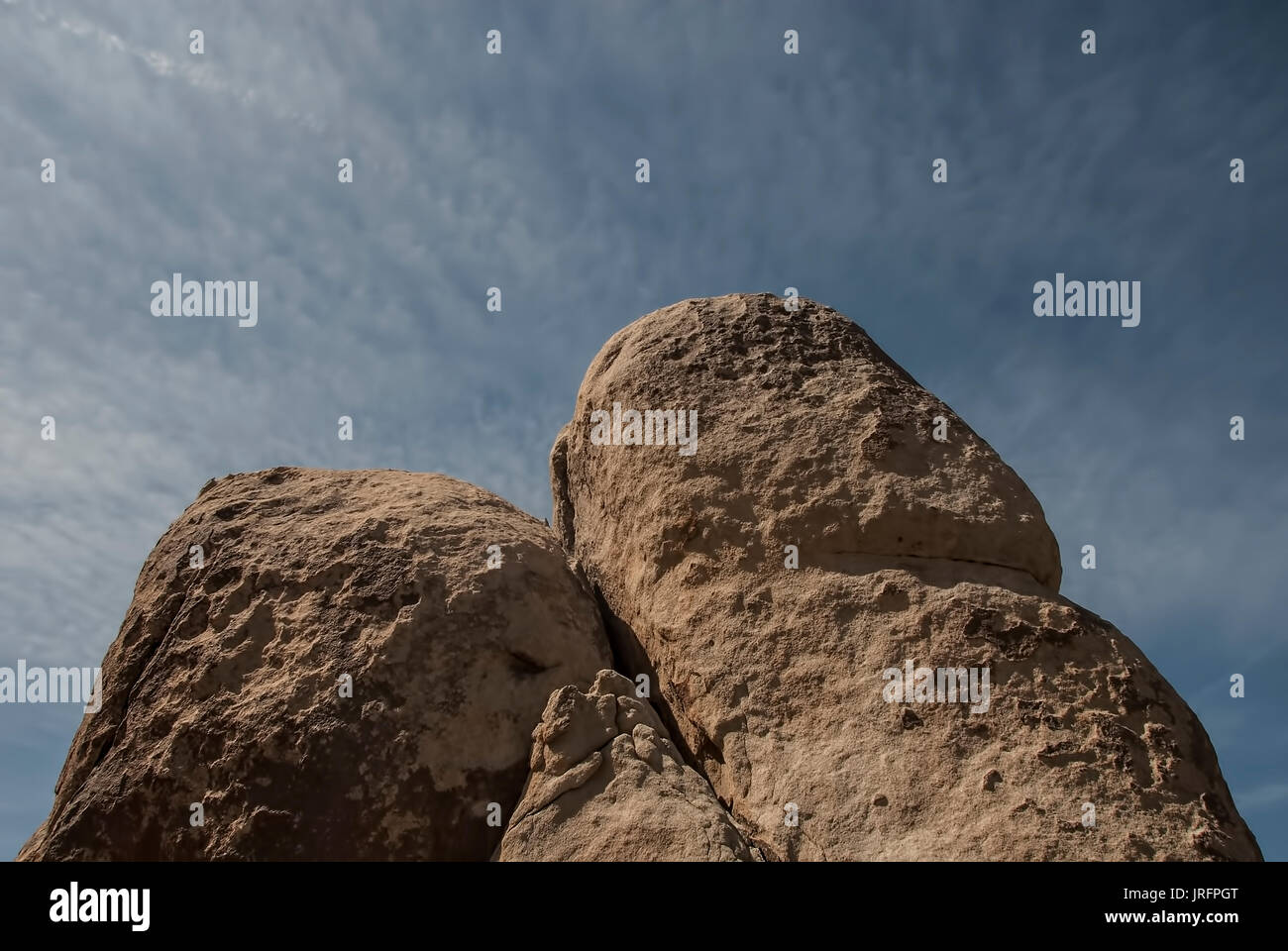 Two boulders rise high against a desert sky Stock Photo - Alamy