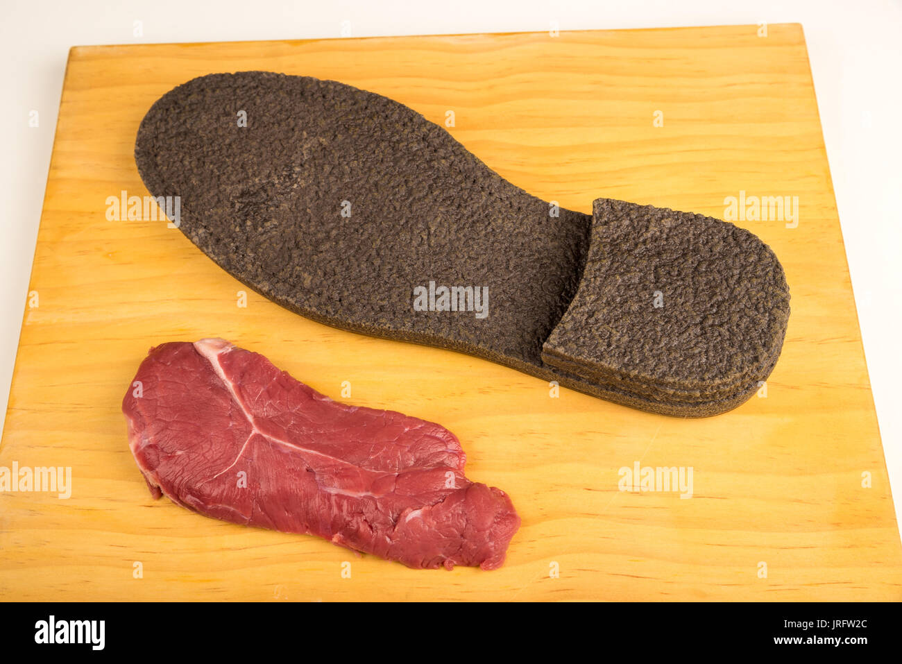 Beef steak next to a shoe sole, a concept for tough, poor quality meat ...