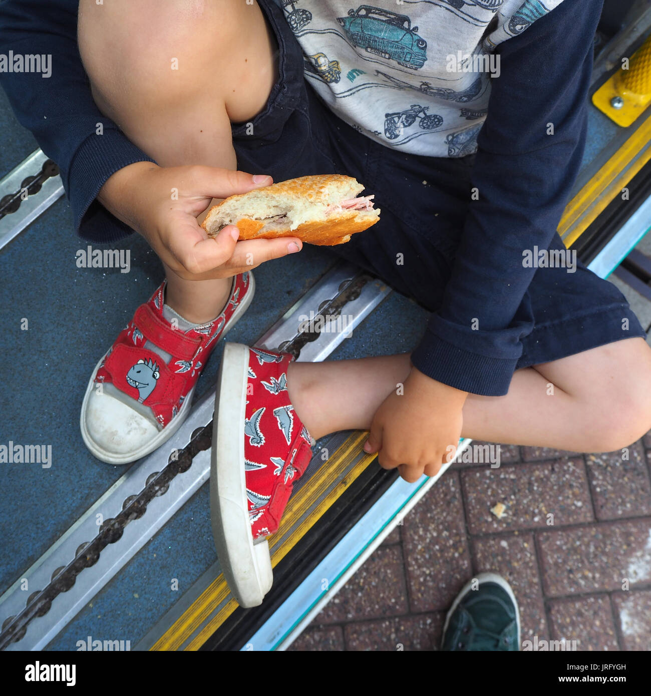 Young boy eating ham baguette Stock Photo - Alamy