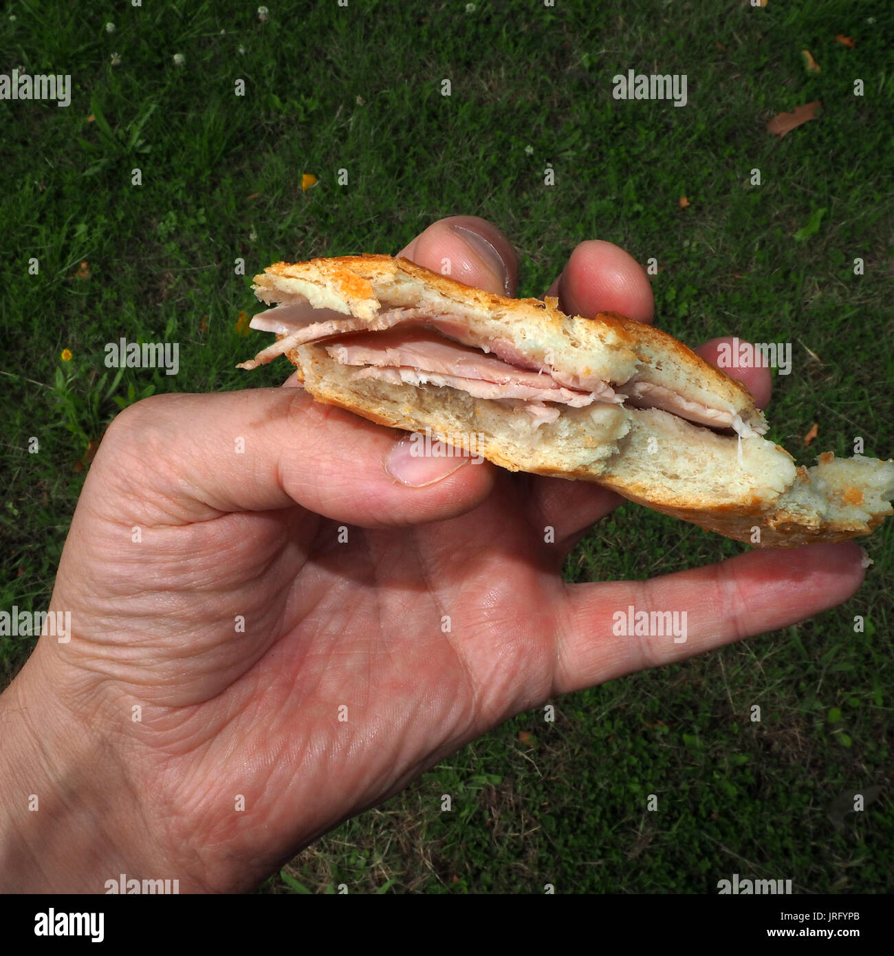 Man holding ham baguette Stock Photo - Alamy