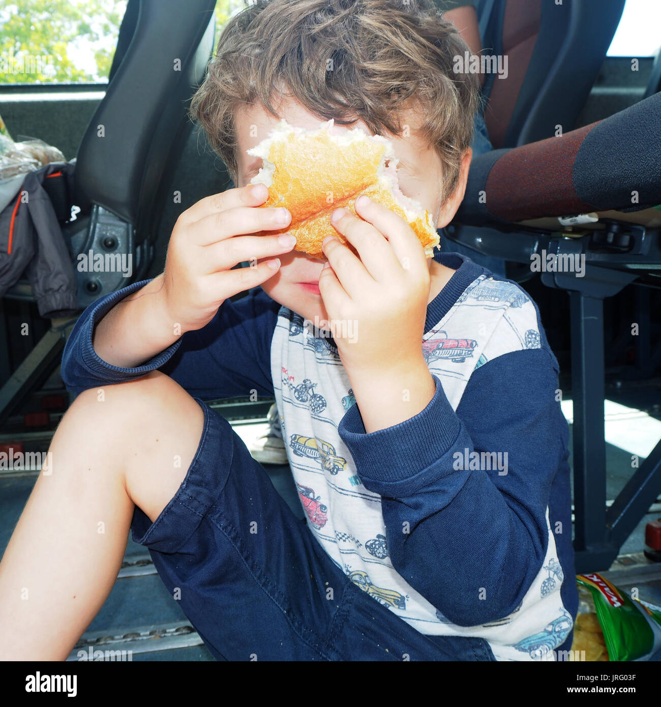 Young boy eating ham baguette Stock Photo - Alamy
