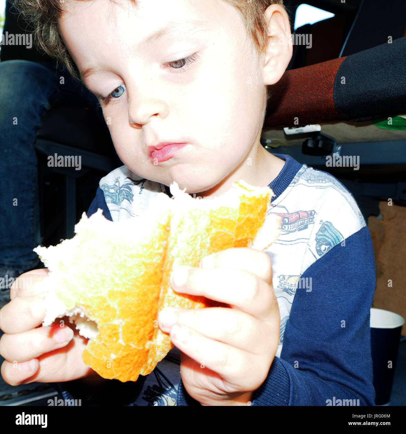 Young boy eating ham baguette Stock Photo - Alamy