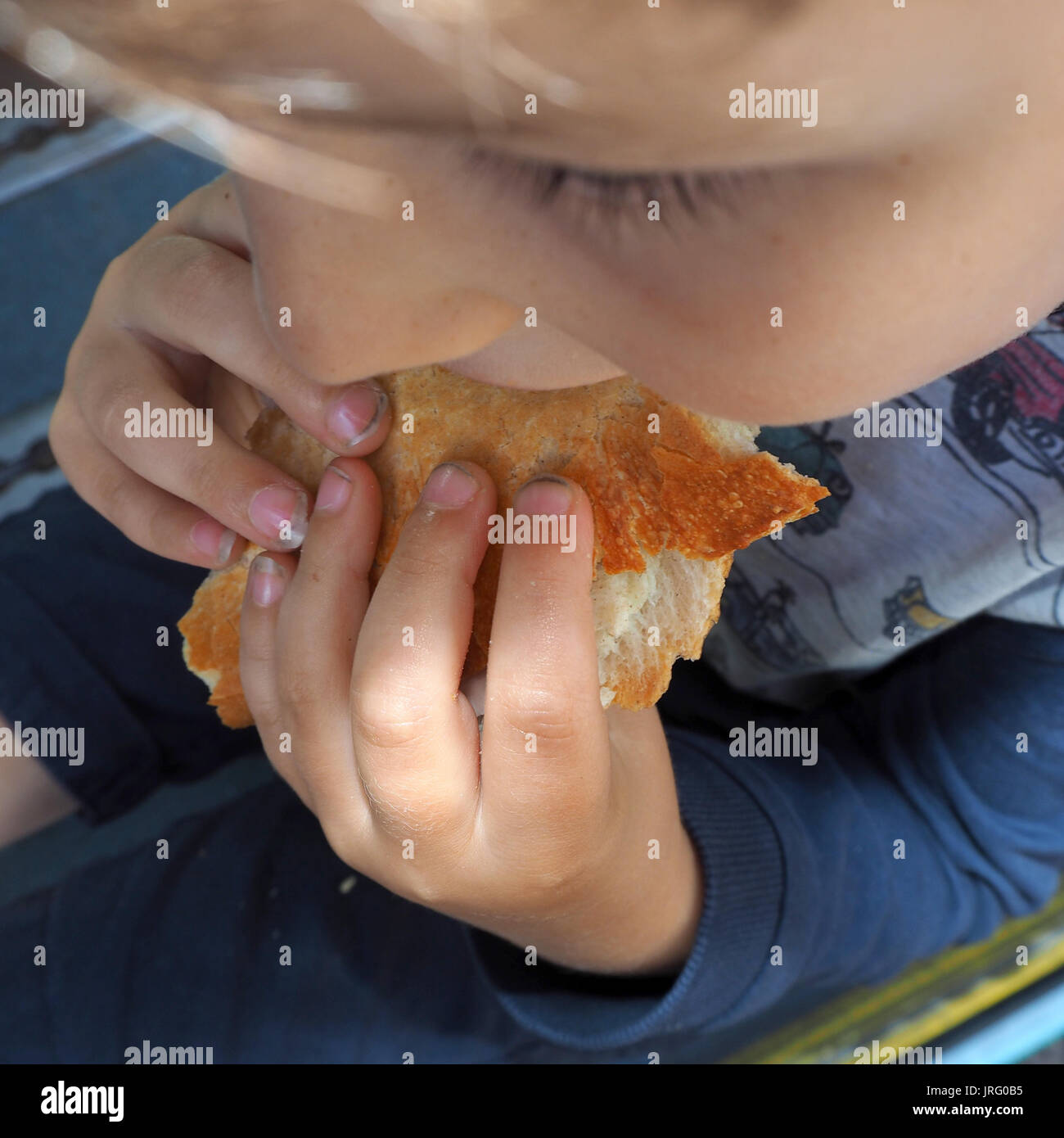 Young boy eating ham baguette Stock Photo - Alamy