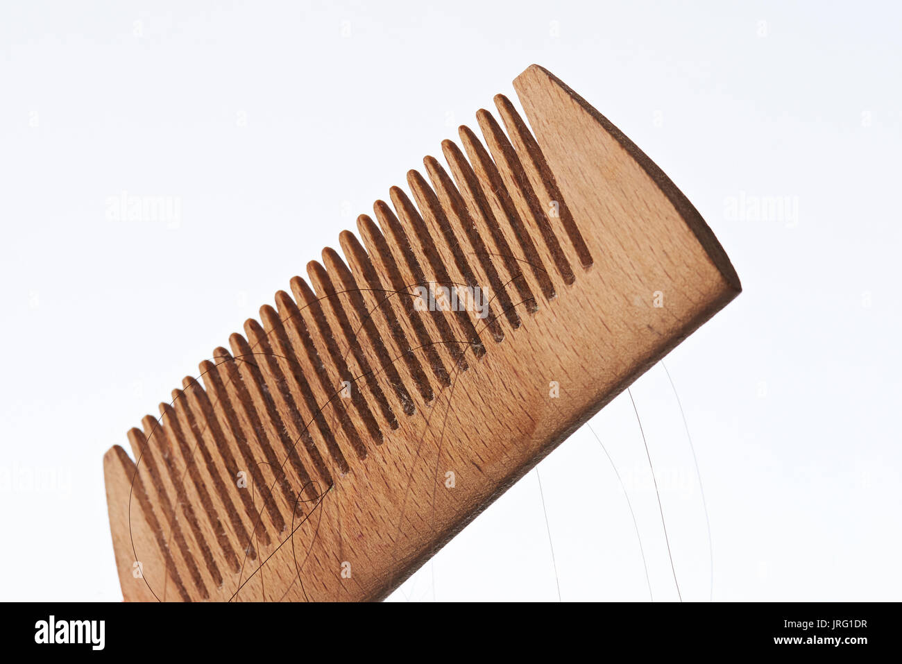 Wooden comb with dark hair strands close-up isolated on white ...