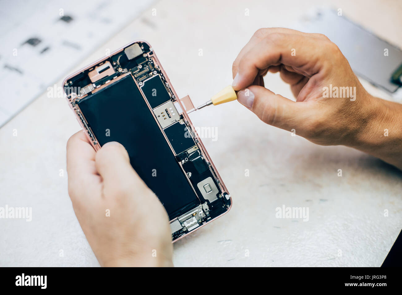 Technician repairs and inserts the sim memory card on the mobile phone ...