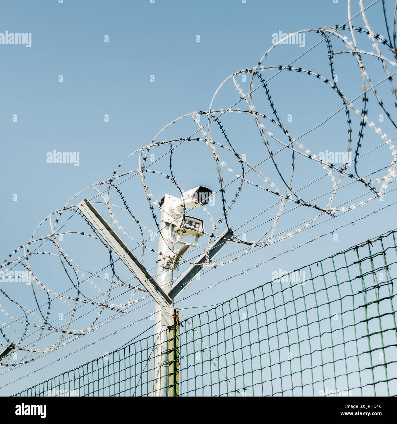 Barbed wire, fence and security camera - dystopian theme Stock Photo ...