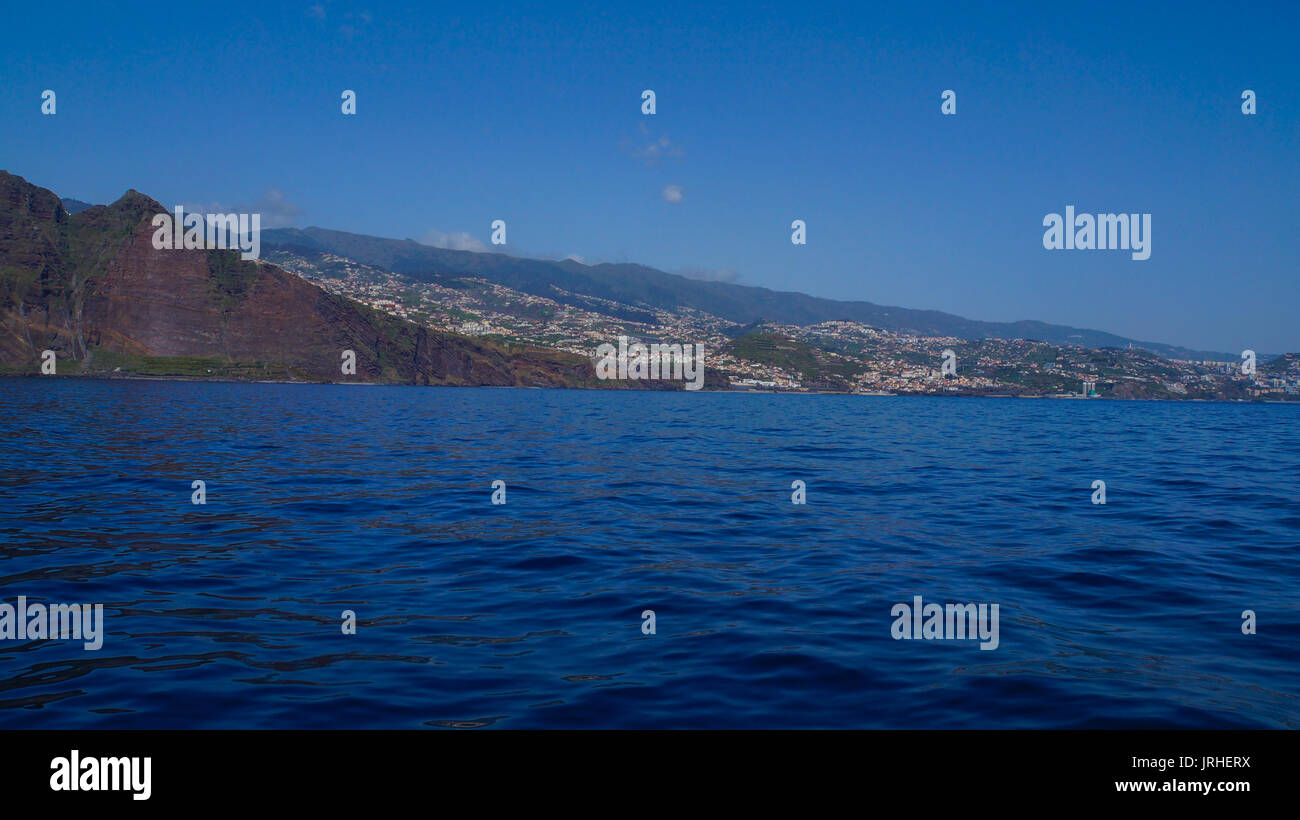 Madeira - Cliffs and blue sky and ocean water from boat near Funchal ...