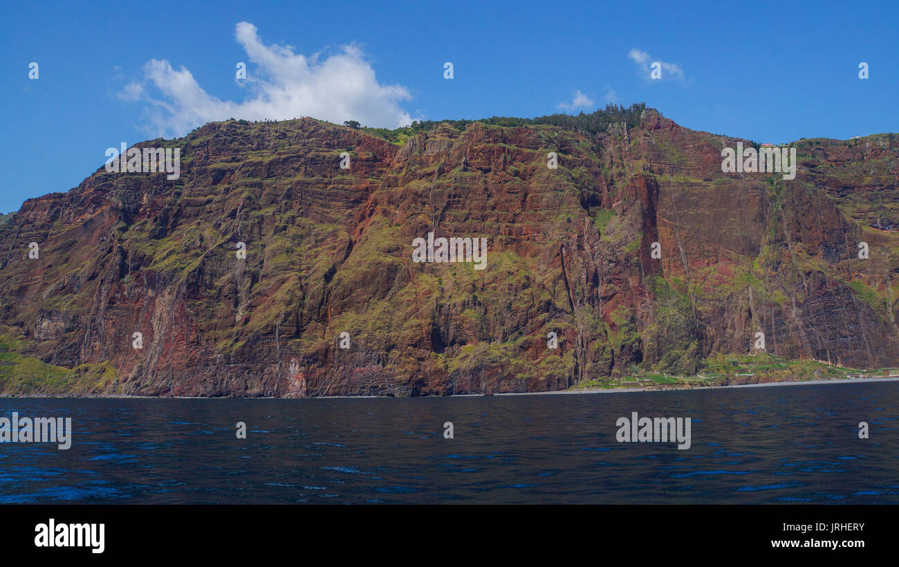 Madeira - Giant red cliffs and blue sky and ocean water from boat ...