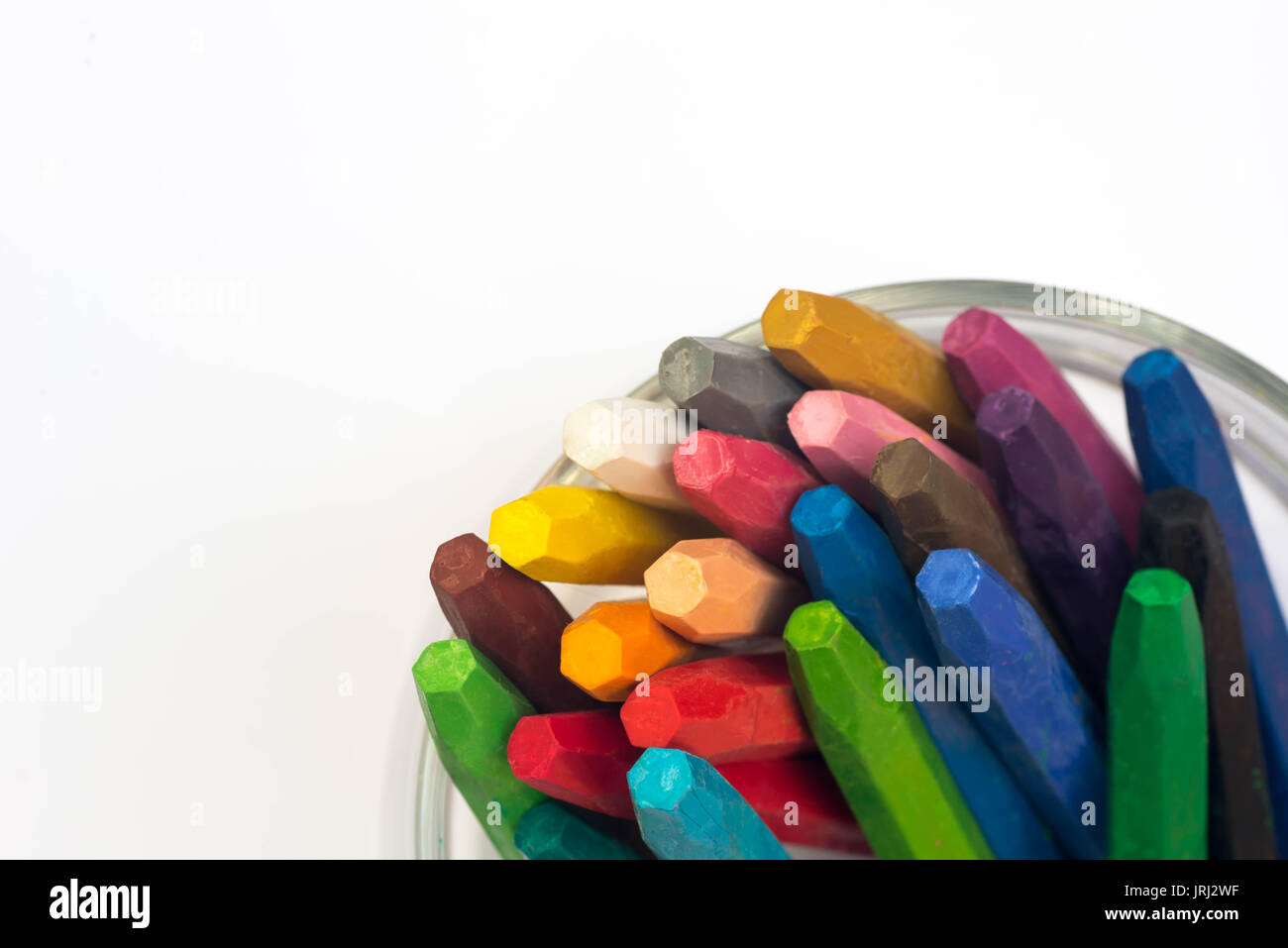 multicolored crayons in cup on white paper Stock Photo - Alamy