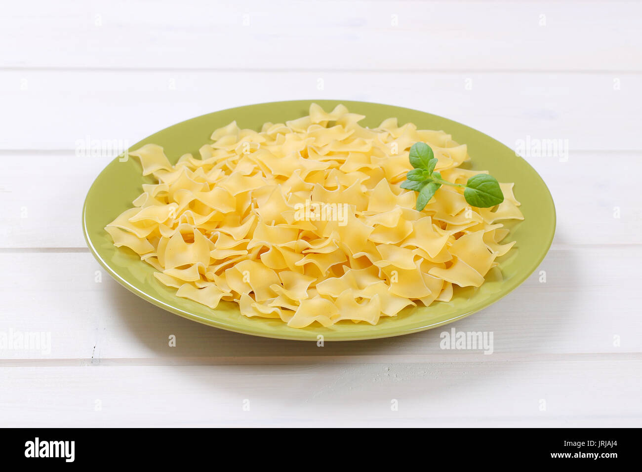 plate of quadretti - square shaped pasta on white wooden background ...