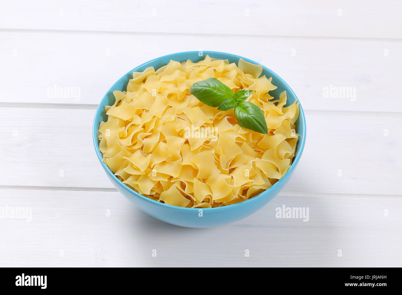 bowl of quadretti - square shaped pasta on white wooden background ...