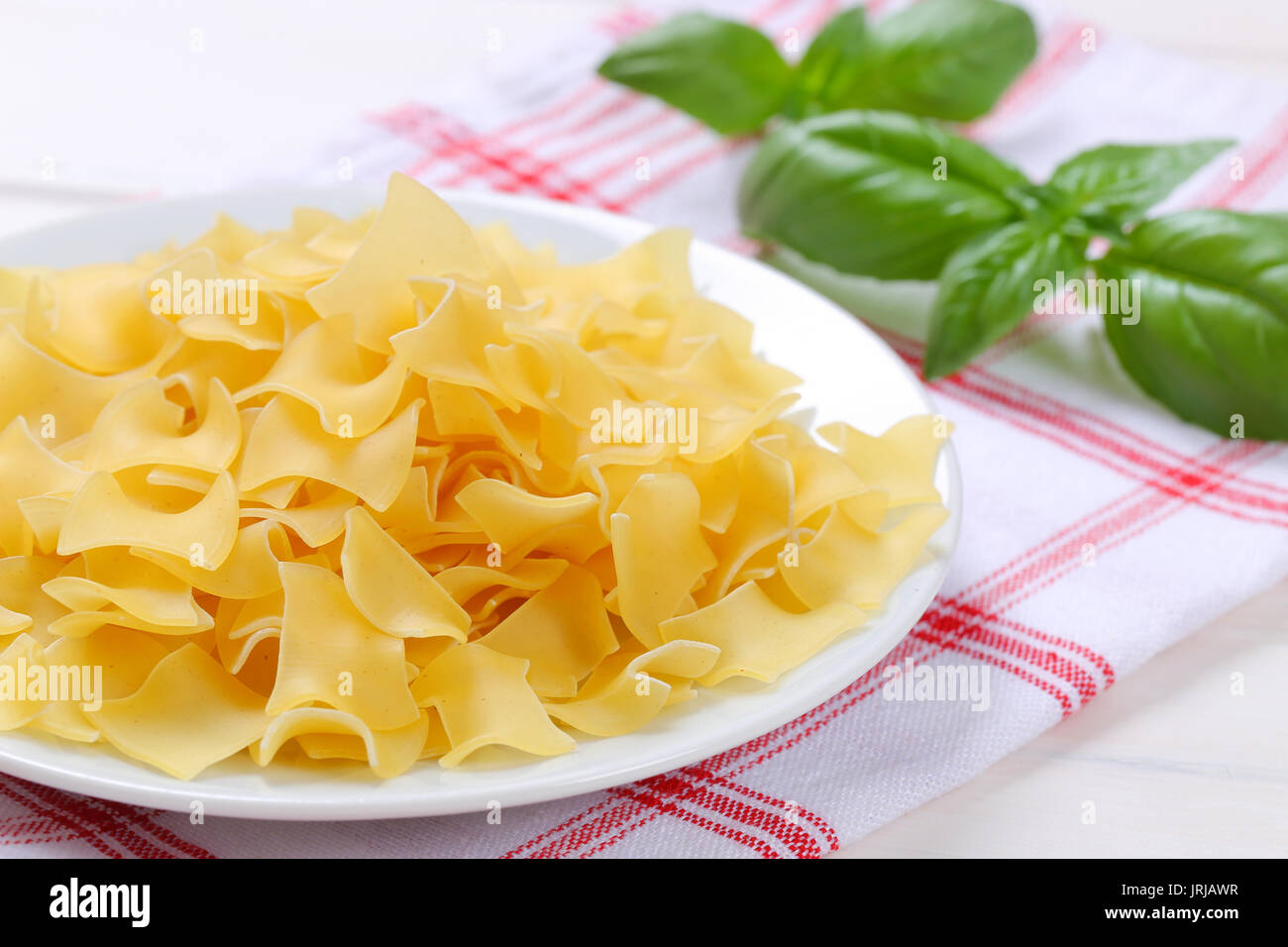 plate of quadretti - square shaped pasta on checkered dishtowel - close ...